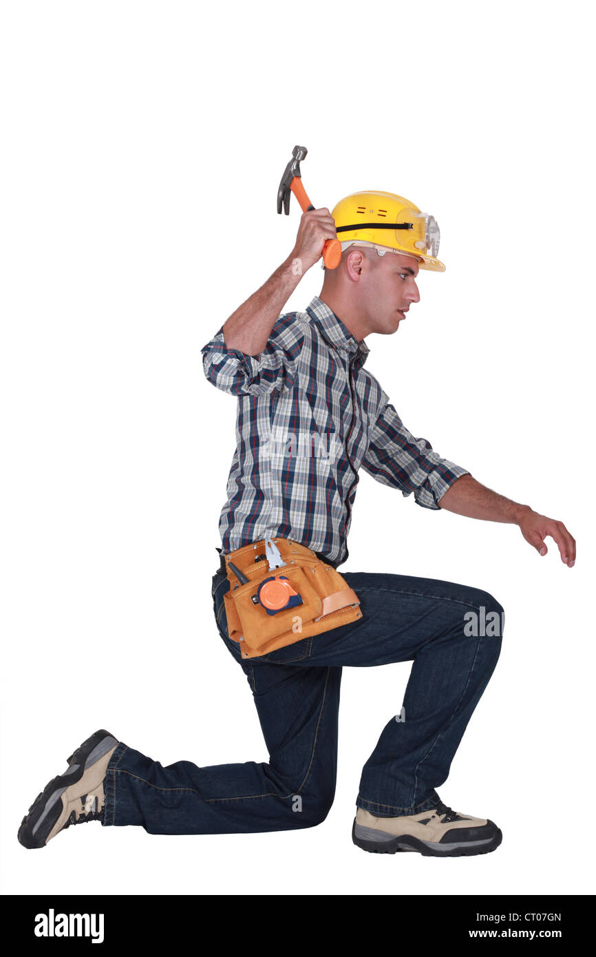 carpenter in profile using hammer Stock Photo - Alamy