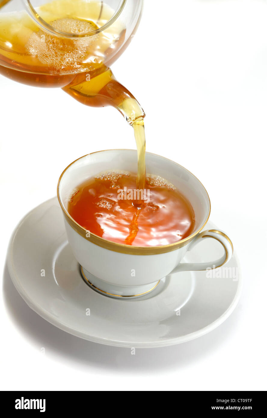 Pouring tea from the tea pot to the cups Stock Photo - Alamy