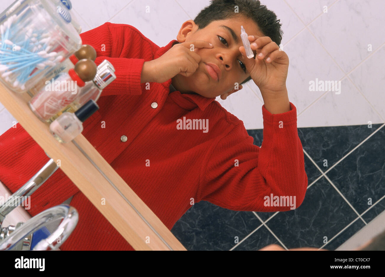 CHILD USING EYE LOTION Stock Photo - Alamy