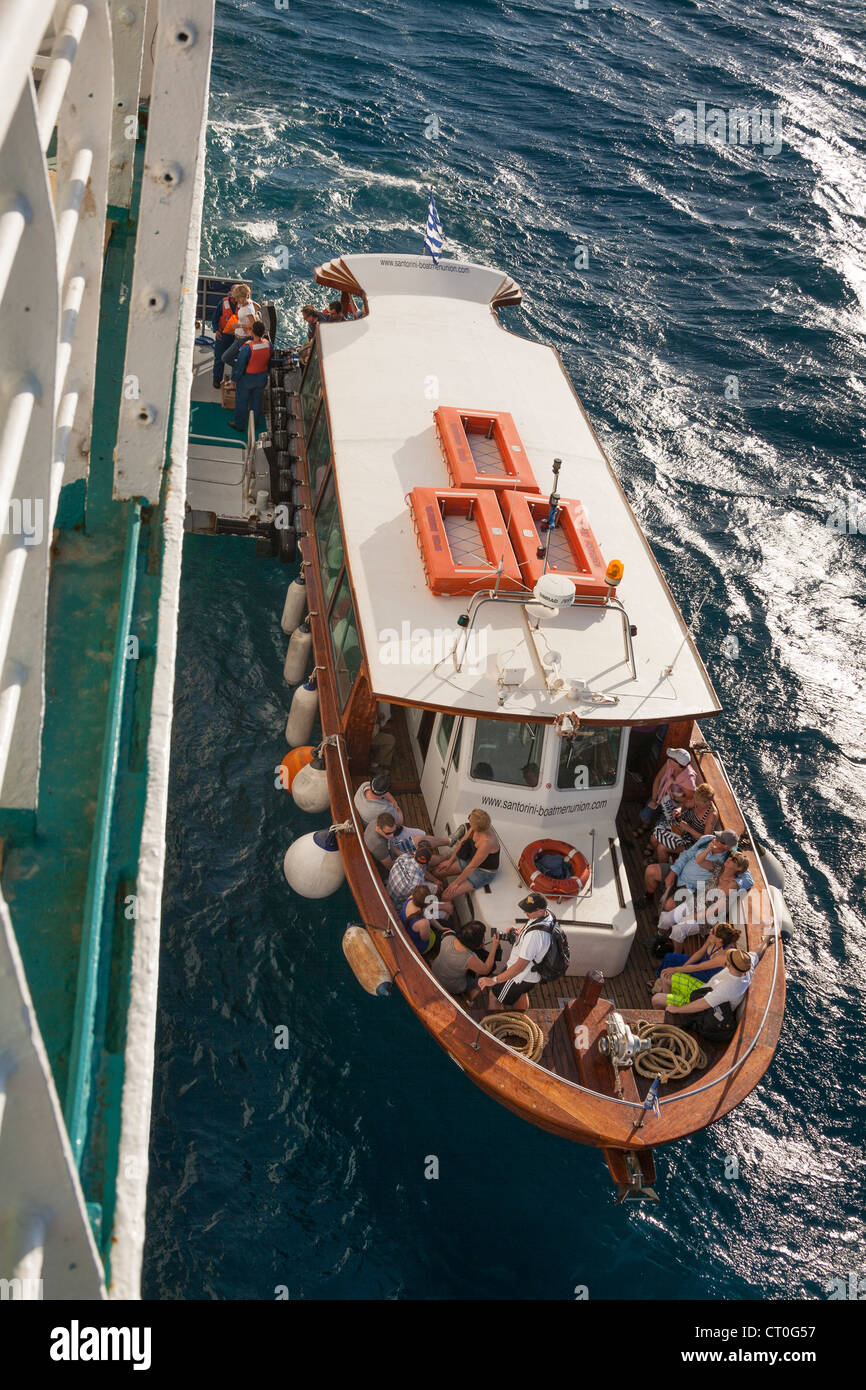 Passengers disembarking from a tender and boarding a cruise ship ...