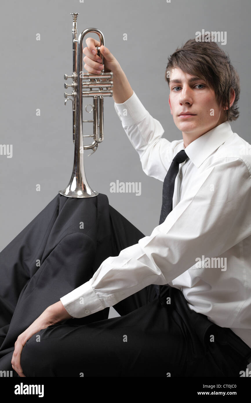 Portrait of a young jazz man and his Trumpet grey background Stock ...