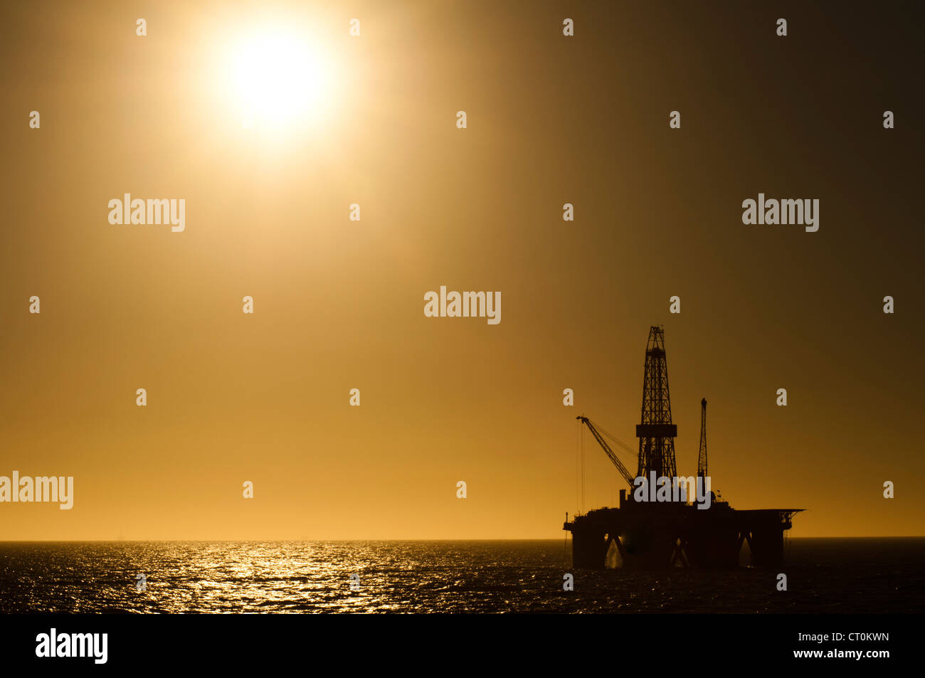 Silhouette of an oil drilling rig in sunset/sunrise time in offshore ...