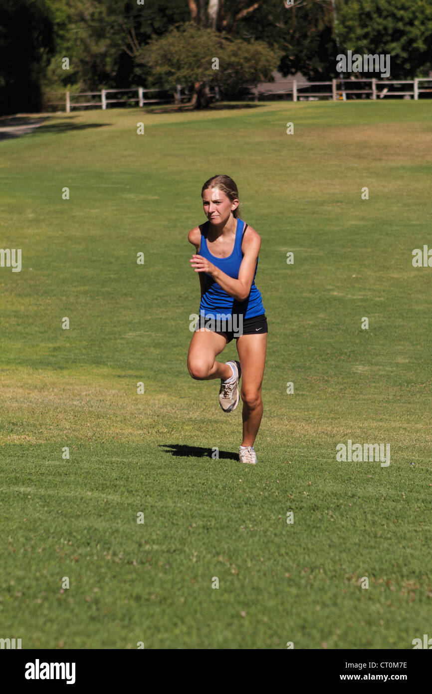 Teenage girl running up a grass hill in the summer Stock Photo - Alamy