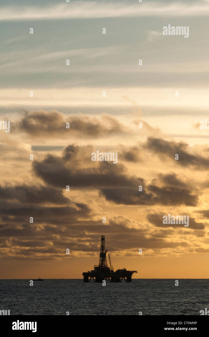 silhouette of offshore oil drilling rig in sunset/sunrise time. Coast ...