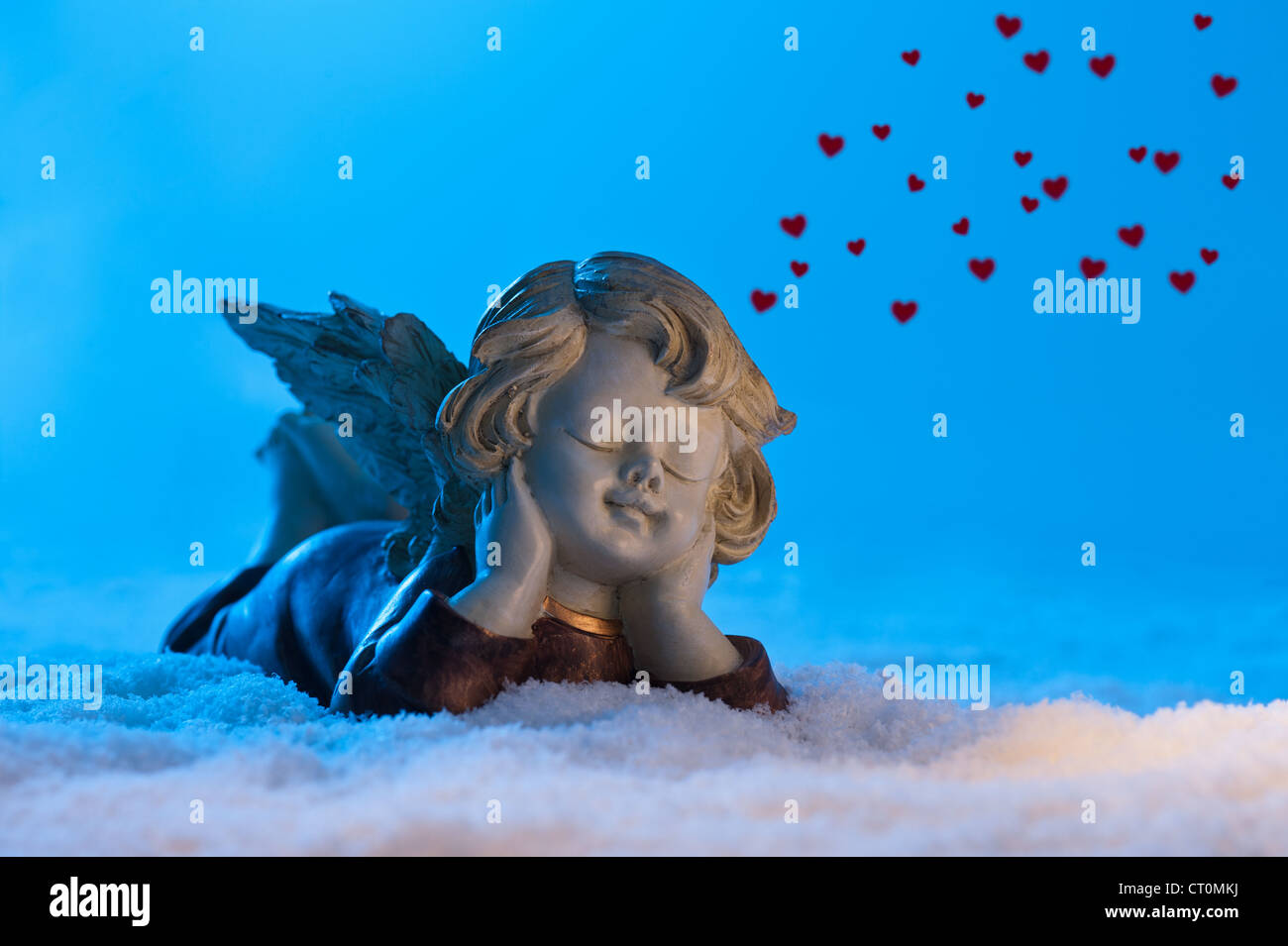 Angel in a beautiful blue snow setting, shows heart Stock Photo - Alamy