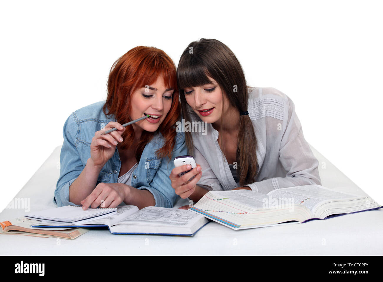 Young women taking a break from studying to read a text message Stock ...