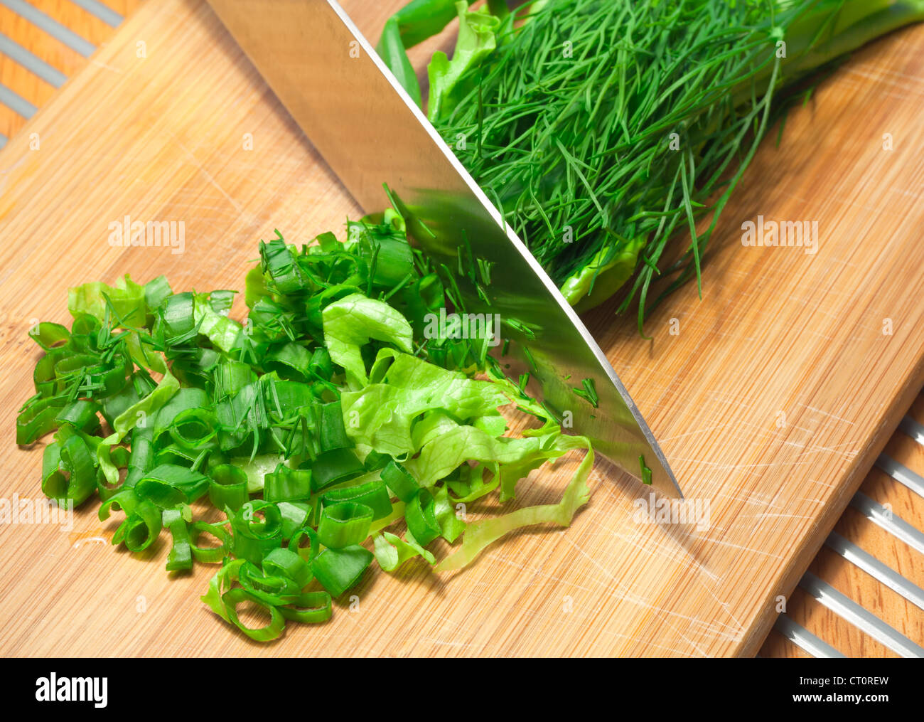 Sliced greens with knife on wooden cutting board Stock Photo - Alamy