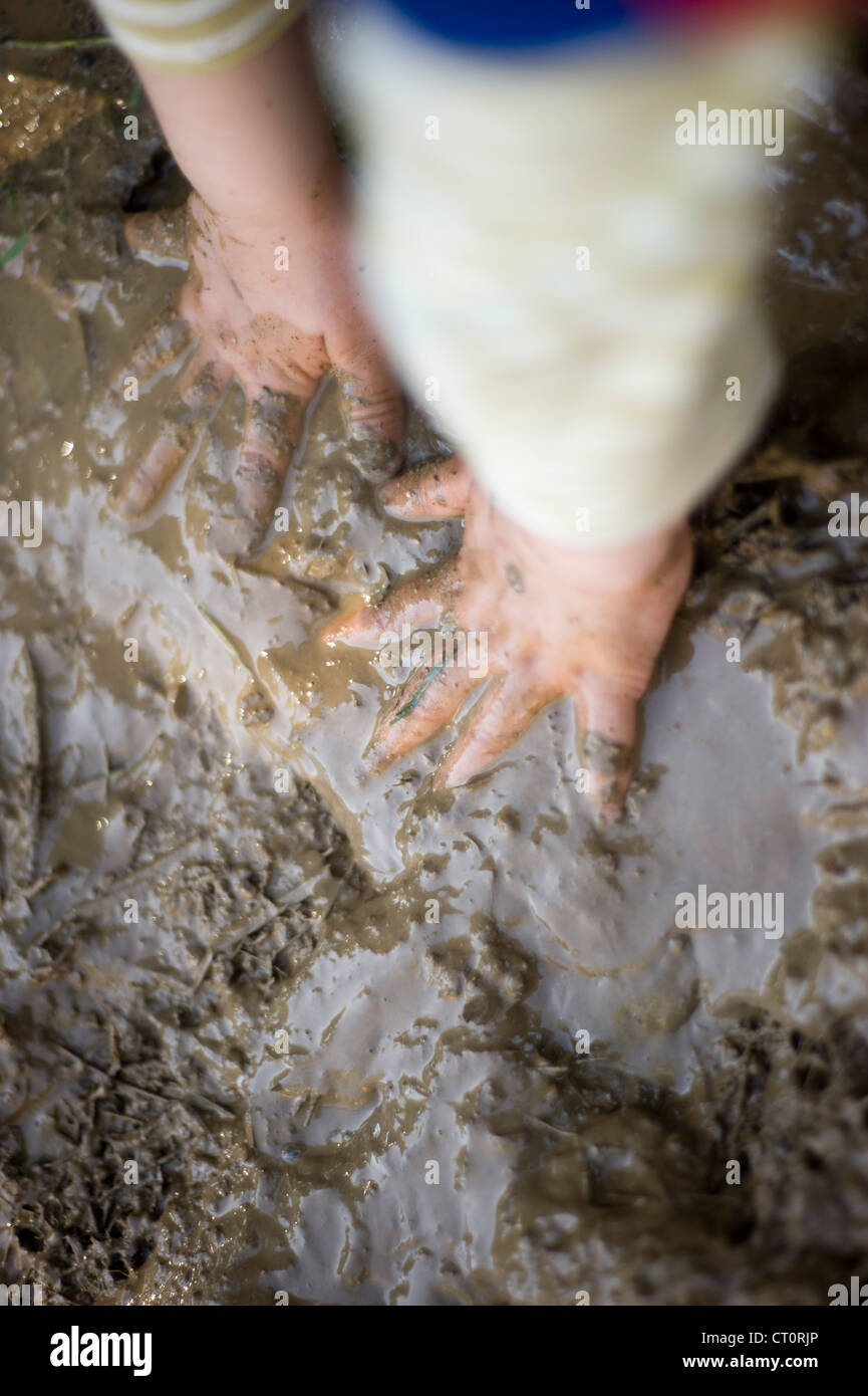 Child playing with his hands in mud Stock Photo - Alamy