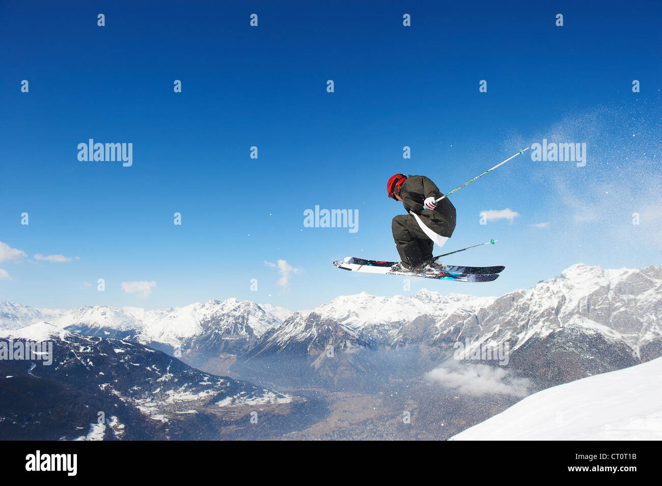 Skier jumping off snowy slope Stock Photo - Alamy