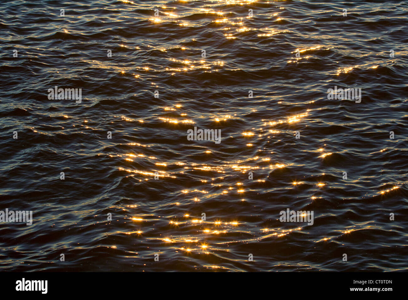 Ocean ripples sparkle with the sunset rays Stock Photo - Alamy
