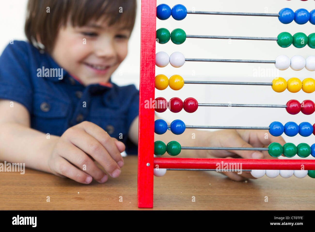 Smiling boy playing with abacus Stock Photo - Alamy