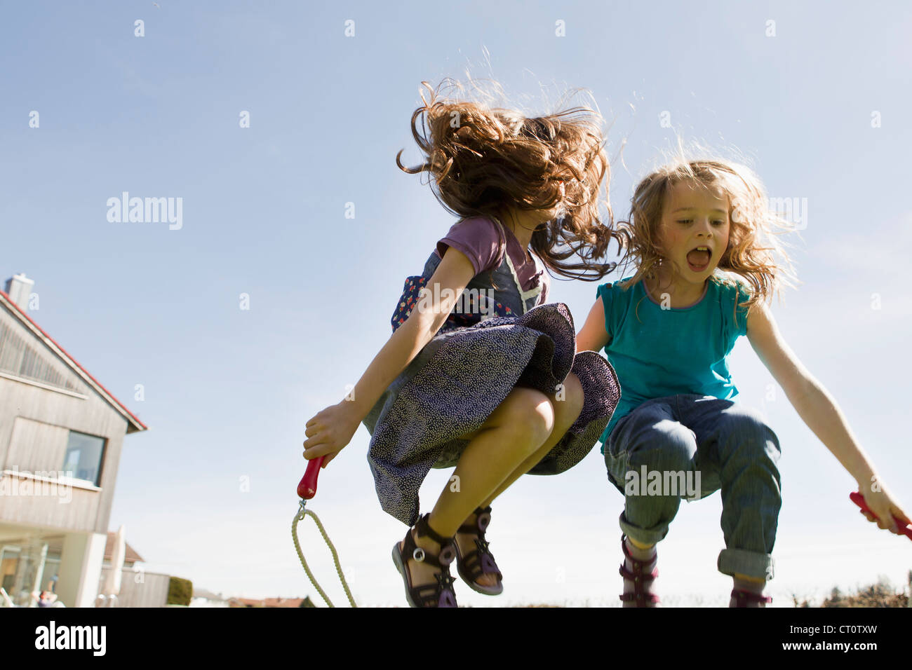 Girls jumping rope together outdoors Stock Photo - Alamy