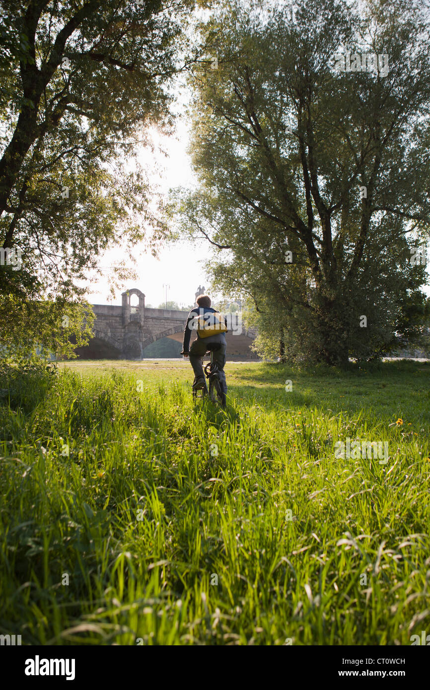 Man riding bicycle in field Stock Photo - Alamy