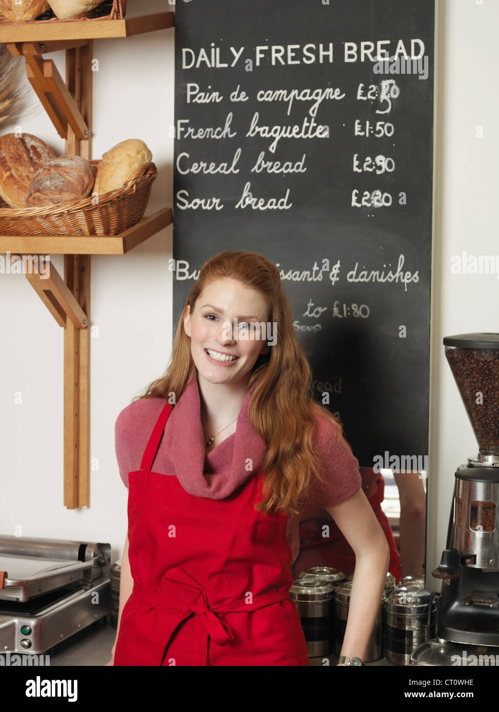 Smiling woman working in bakery Stock Photo - Alamy