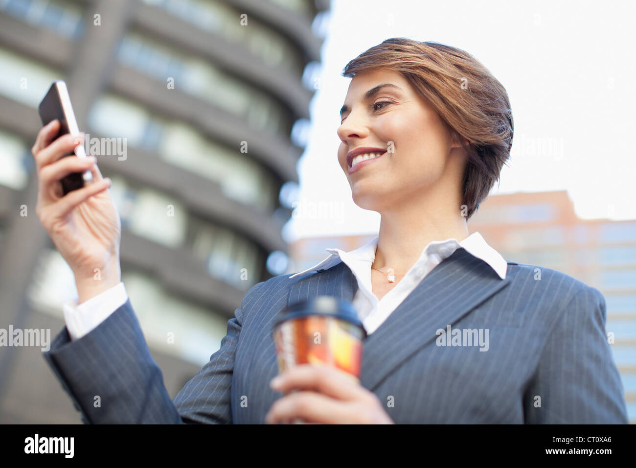 Businesswoman using cell phone outdoors Stock Photo - Alamy