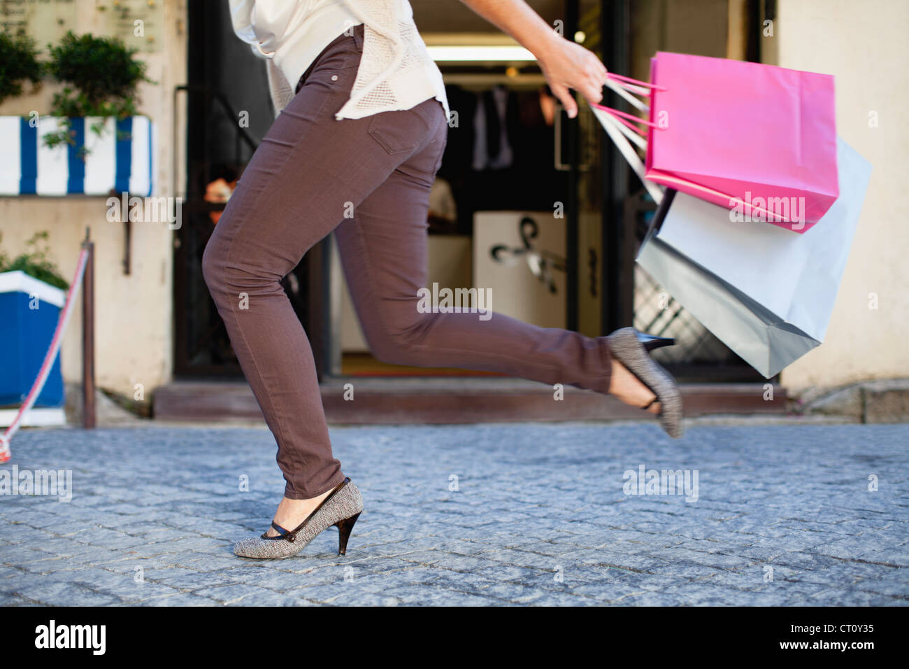 Woman running with shopping bags Stock Photo - Alamy