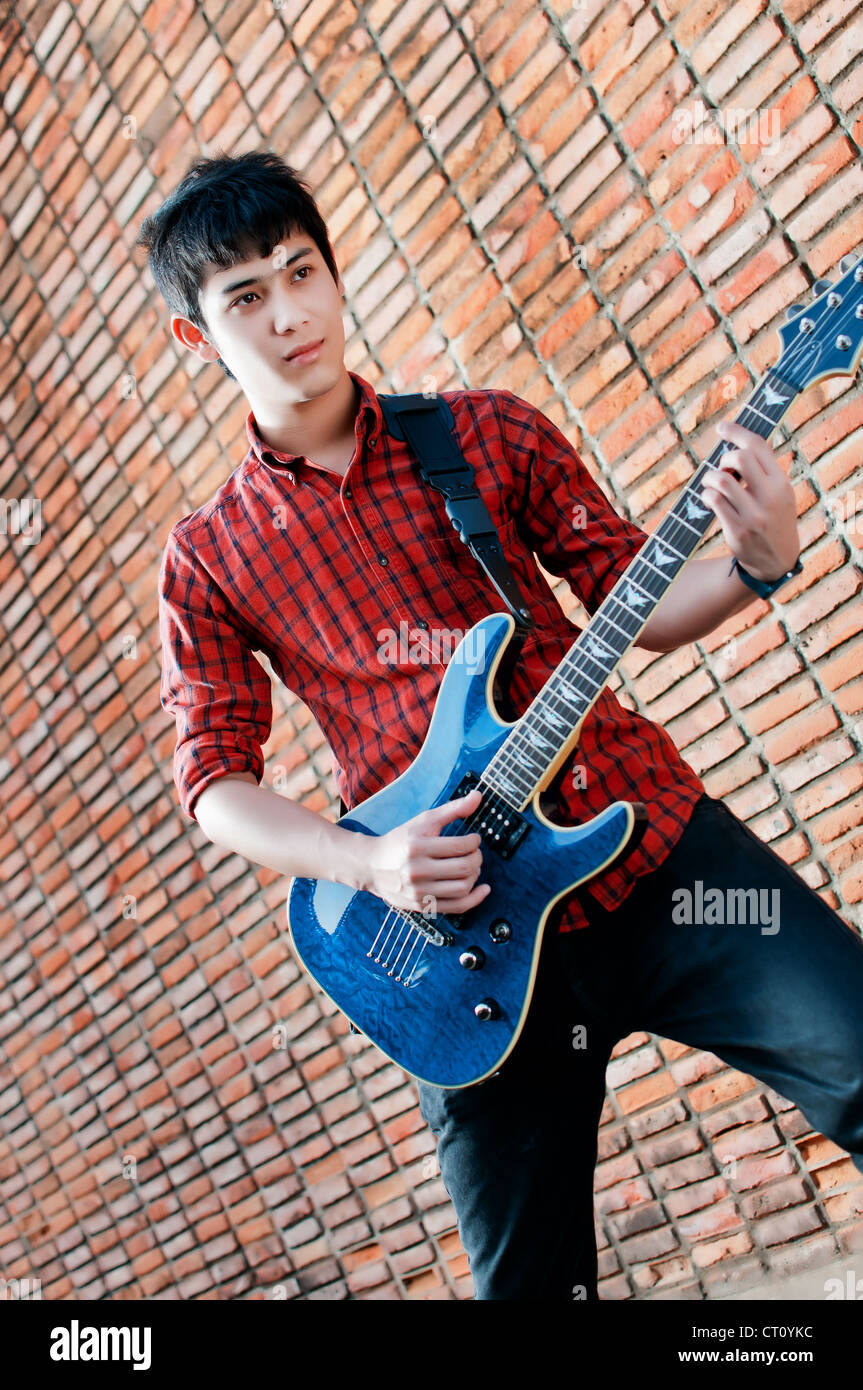 Handsome young musician playing the guitar and singing Stock Photo - Alamy