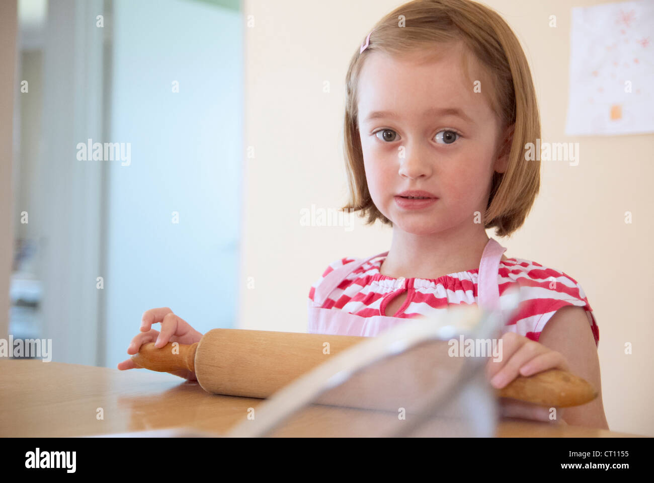 Girl using rolling pin in kitchen Stock Photo - Alamy