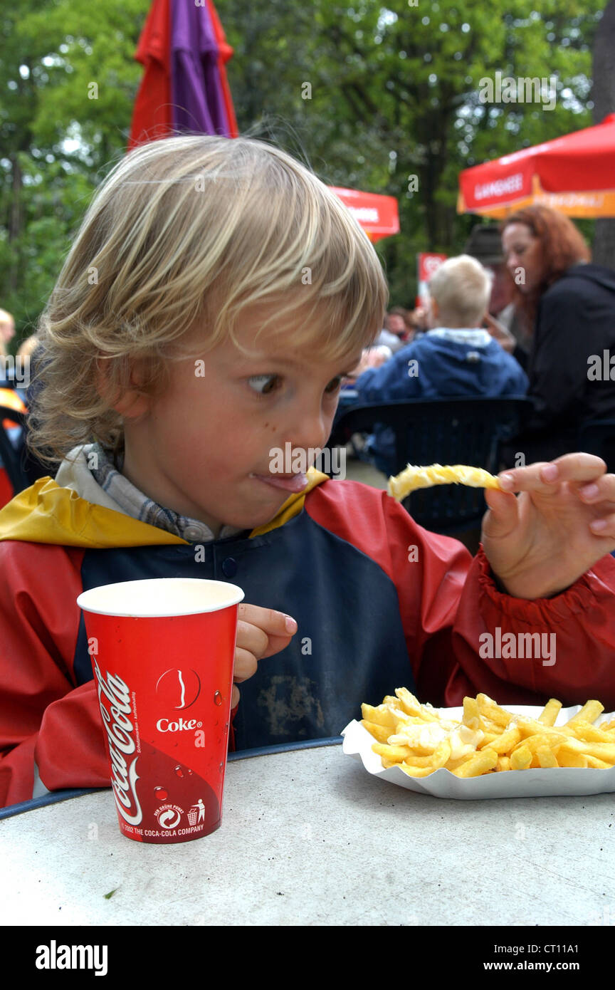 Boy eating french fries Stock Photo - Alamy