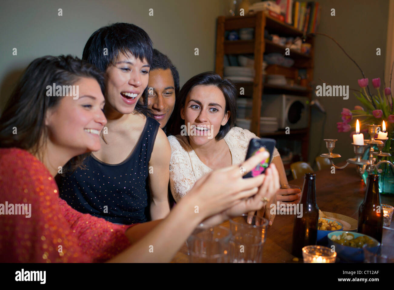 Friends using cell phone at dinner table Stock Photo - Alamy