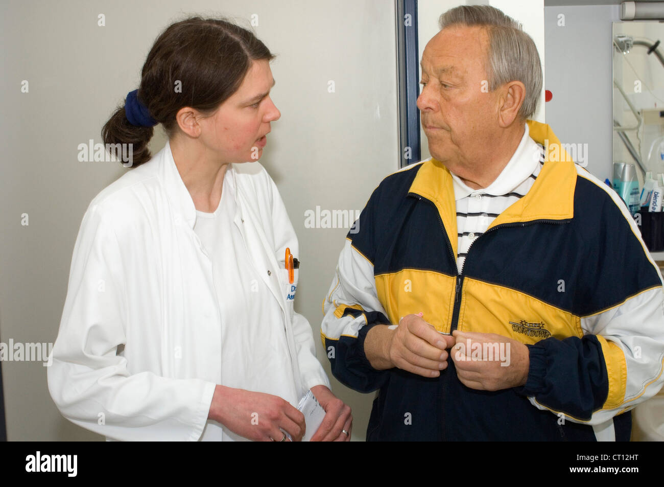 A doctor saying goodbye to a patient who is leaving hospital after ...