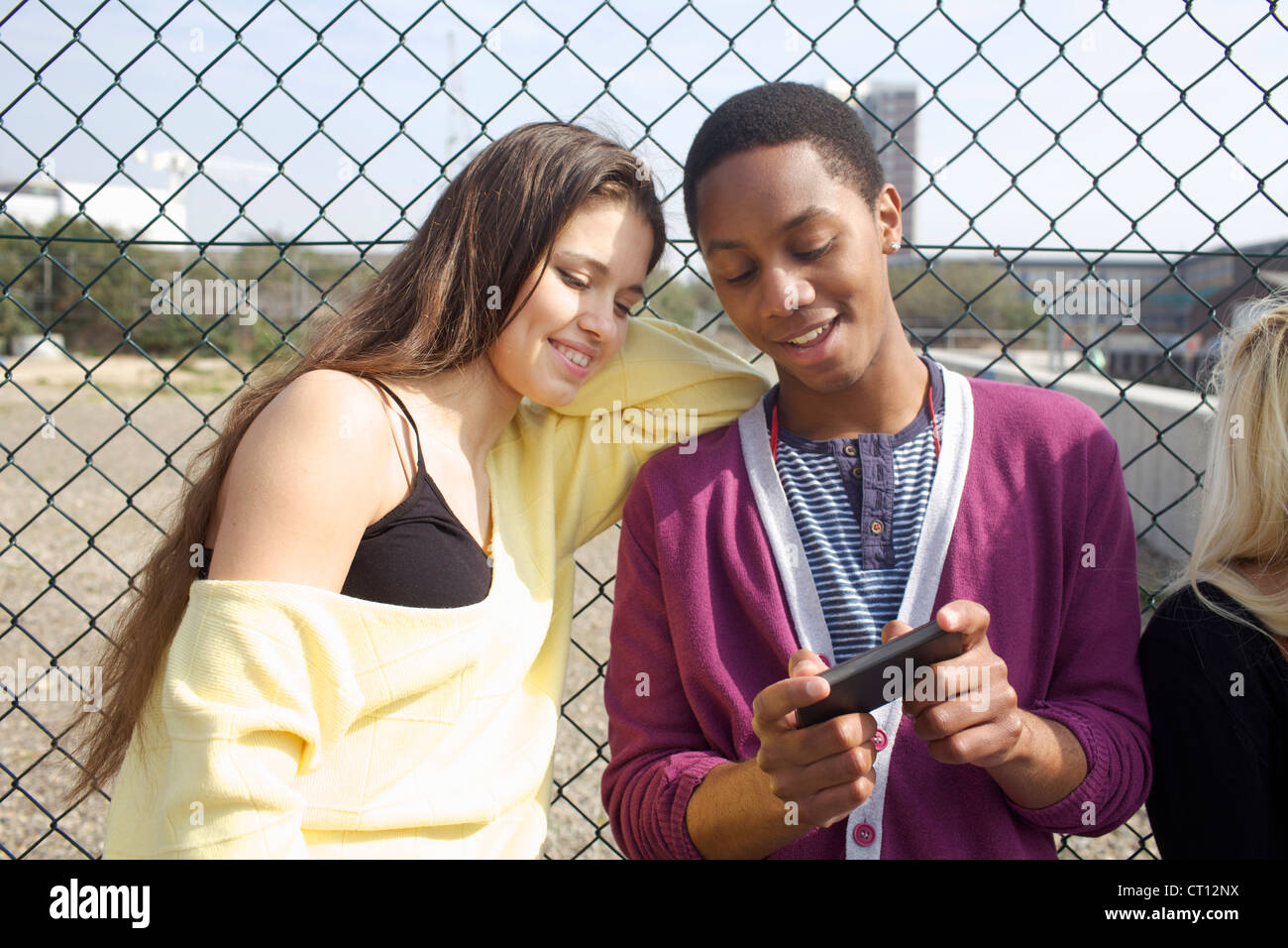 Couple using cell phone on city street Stock Photo - Alamy
