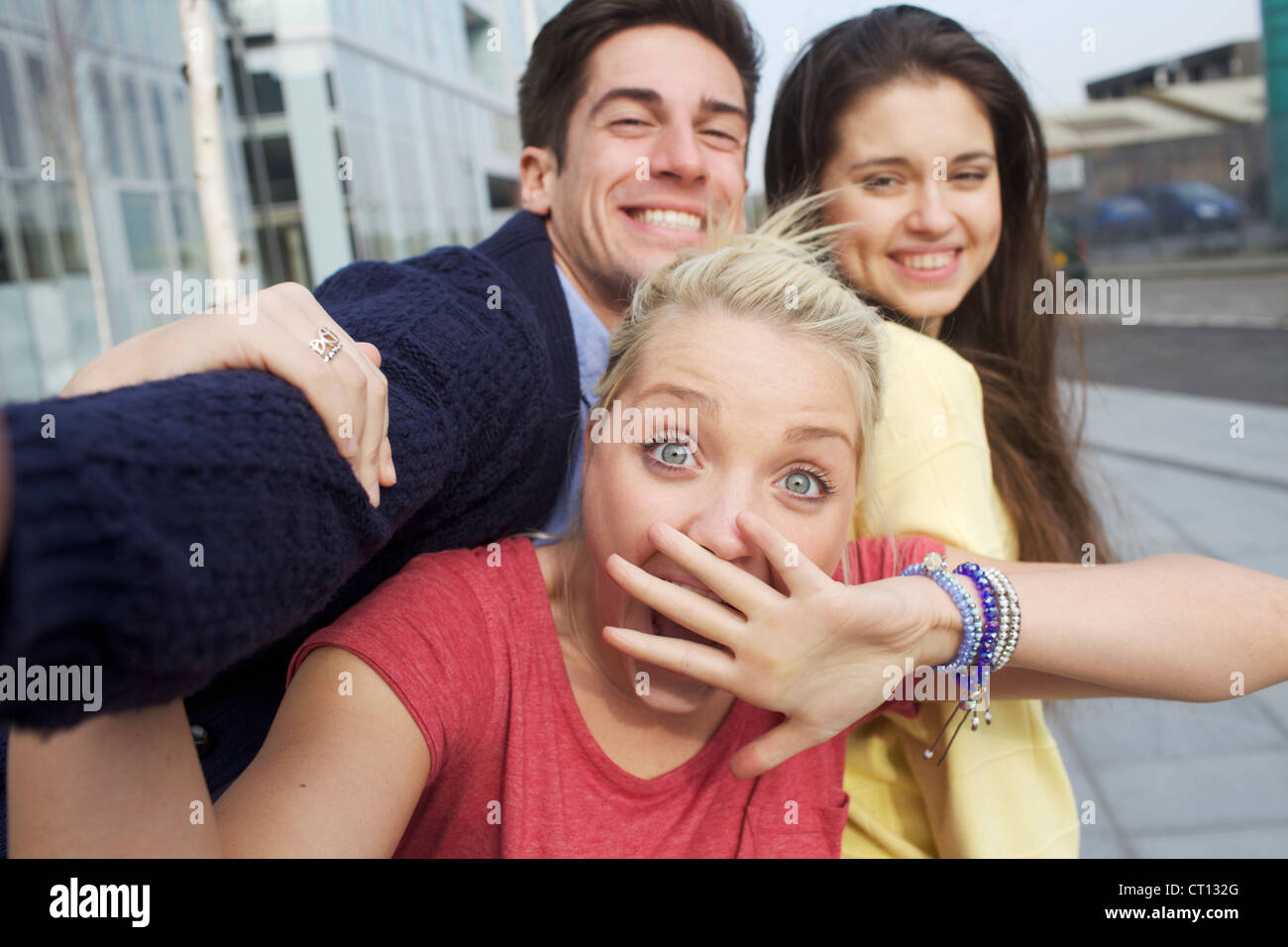 Friends smiling together on city street Stock Photo - Alamy