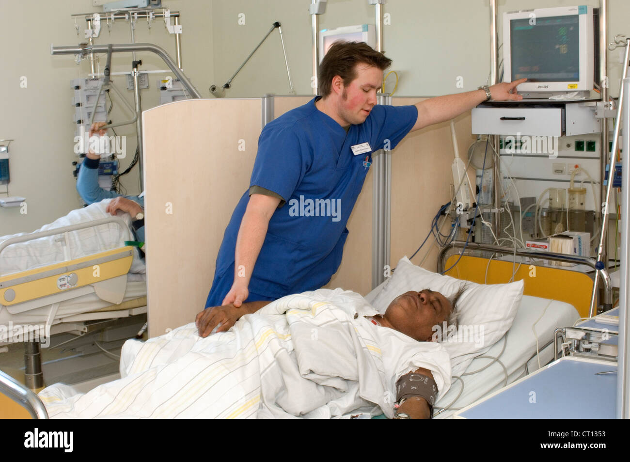 A doctor checking the pulse of a male patient who has undergone an ...