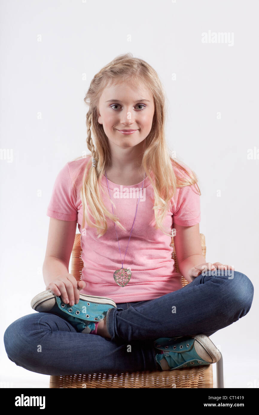 Smiling girl sitting cross legged Stock Photo - Alamy