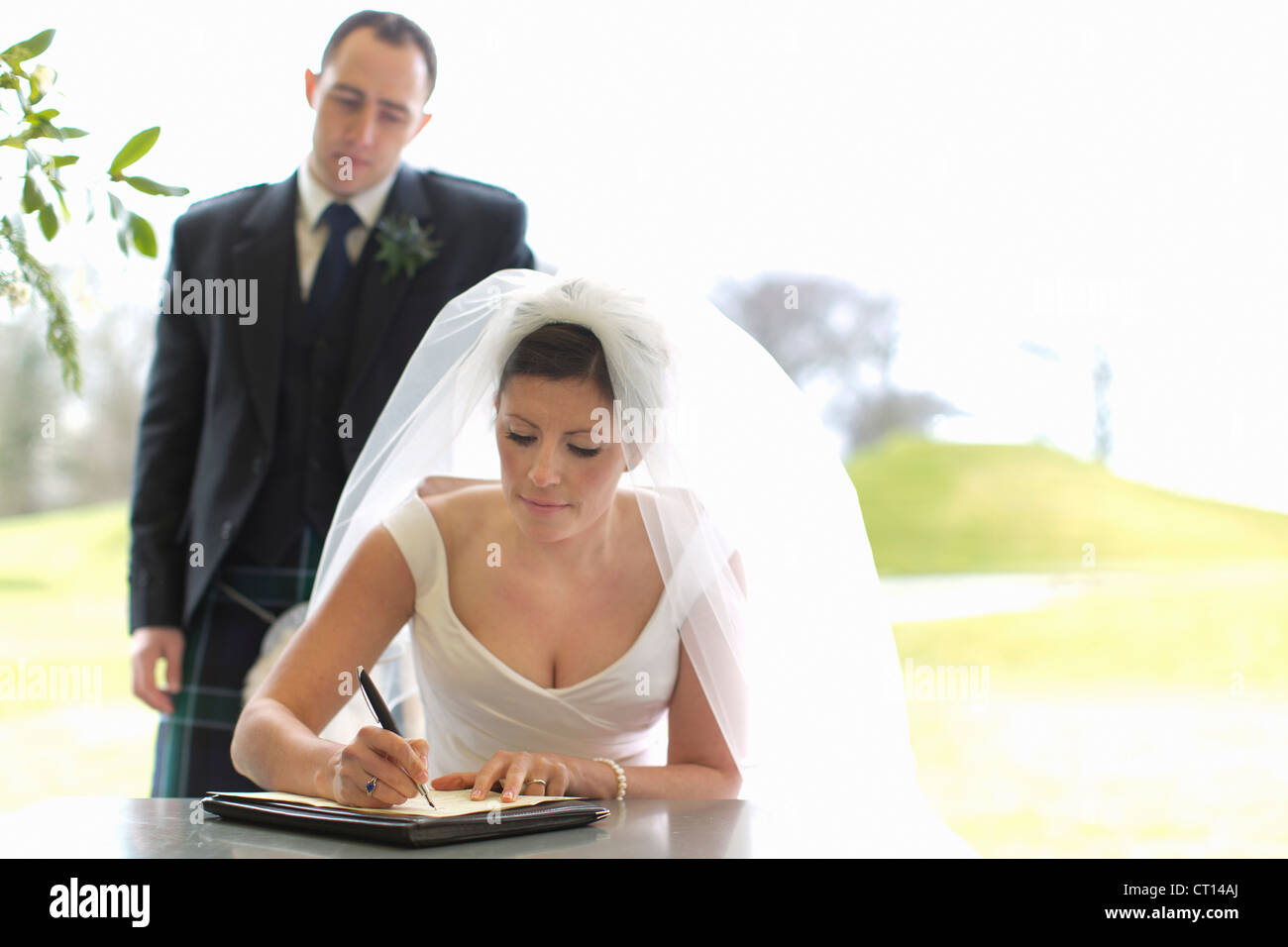 Newlywed couple signing marriage license Stock Photo - Alamy