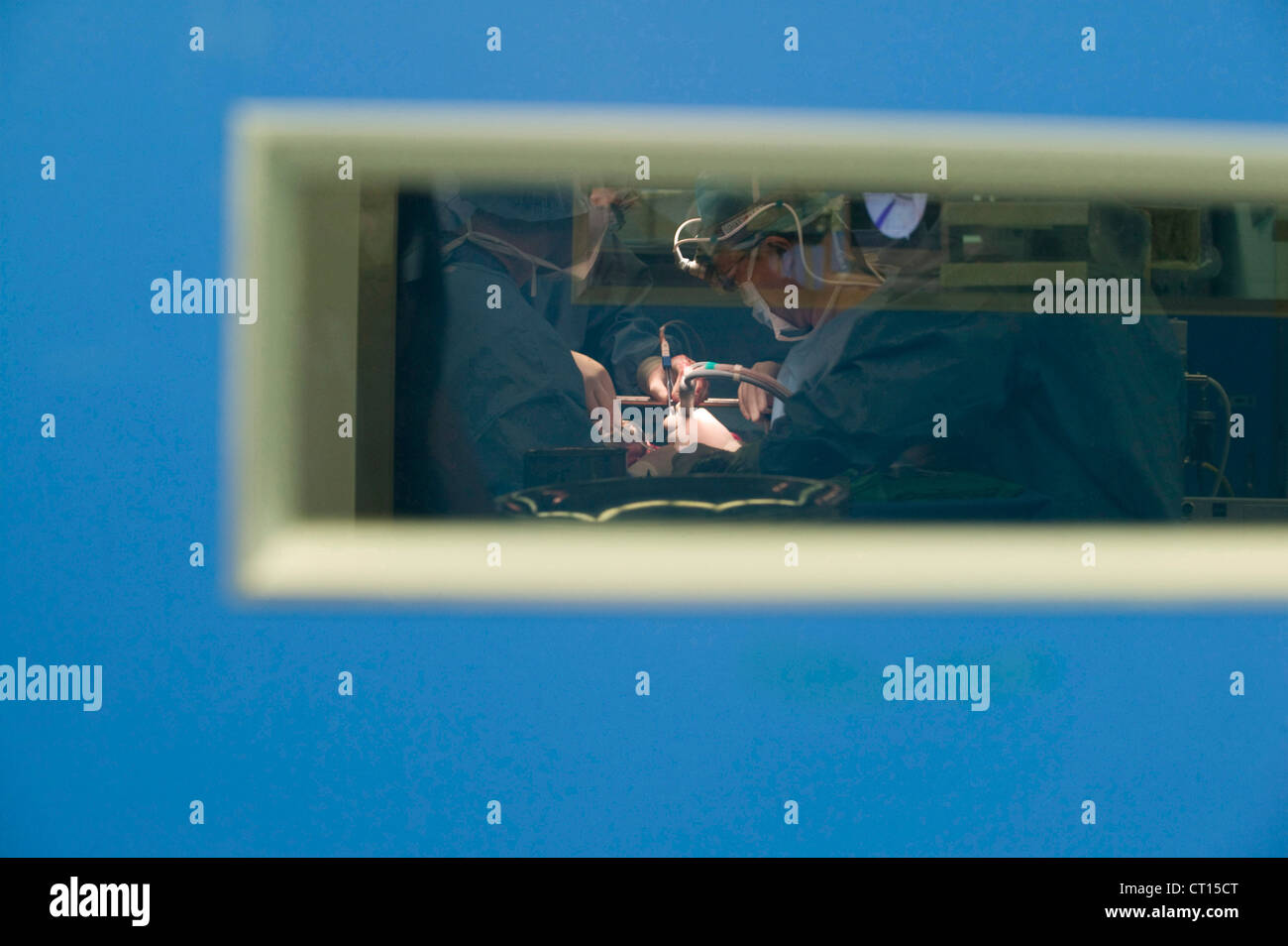 Surgeons performing a liver transplant are seen at work through a ...