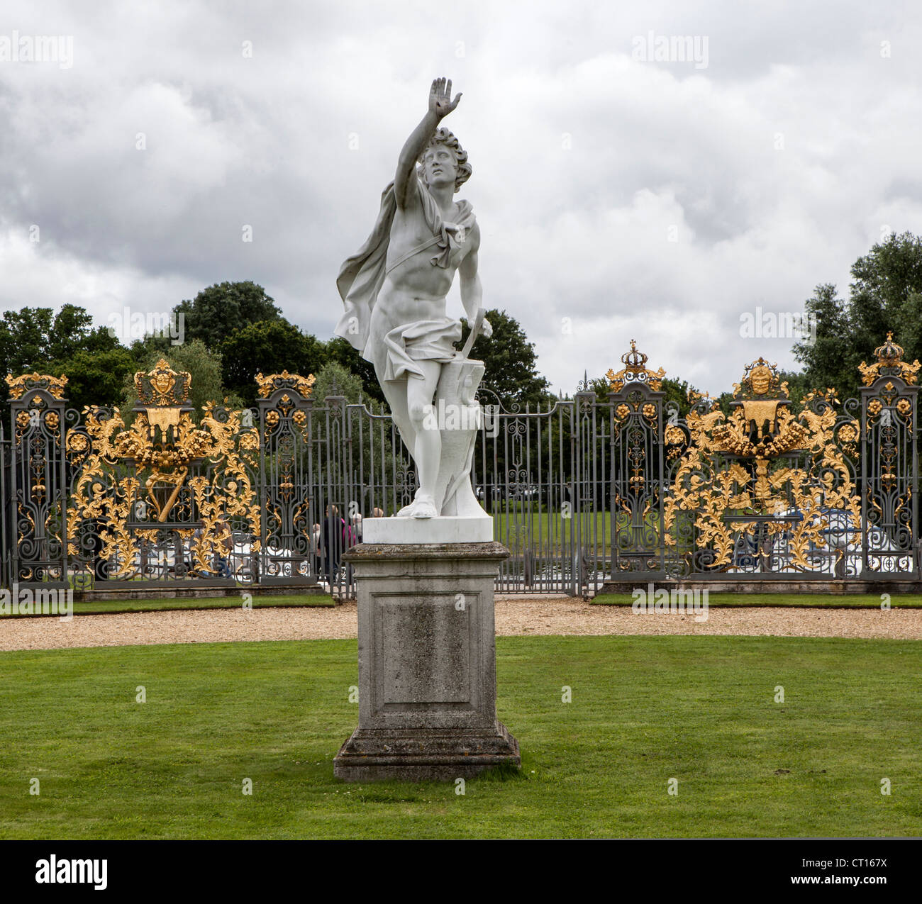 A statue stands in front of the ornate wrought iron fence designed by ...