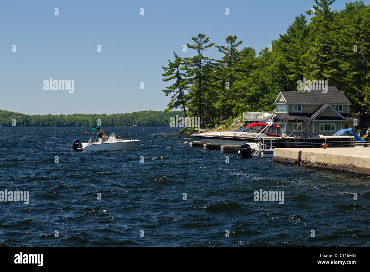 Boat returning to the cottage Stock Photo - Alamy