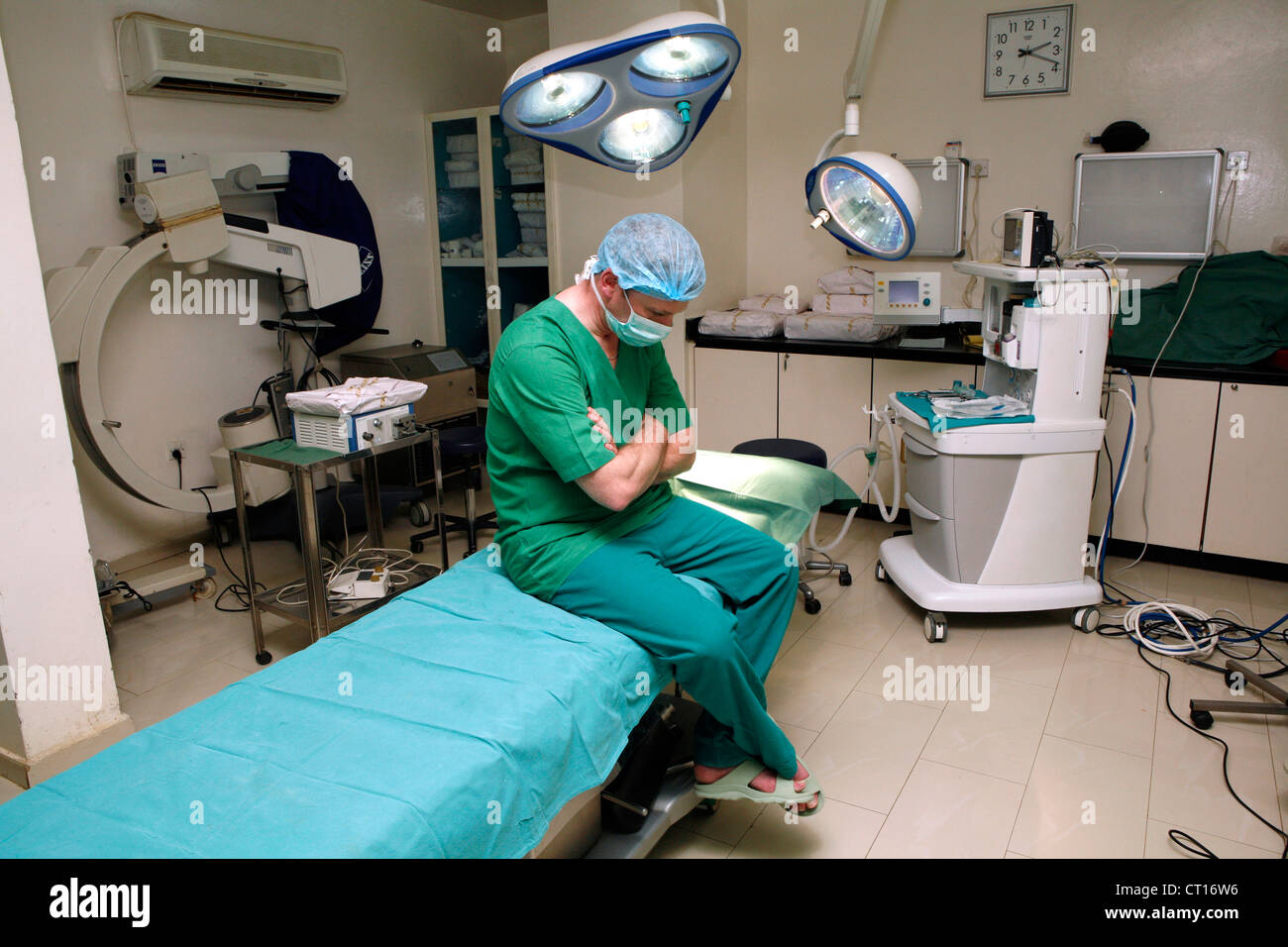 A tired Surgeon sleeps sits on the theatre table and rests Stock Photo ...