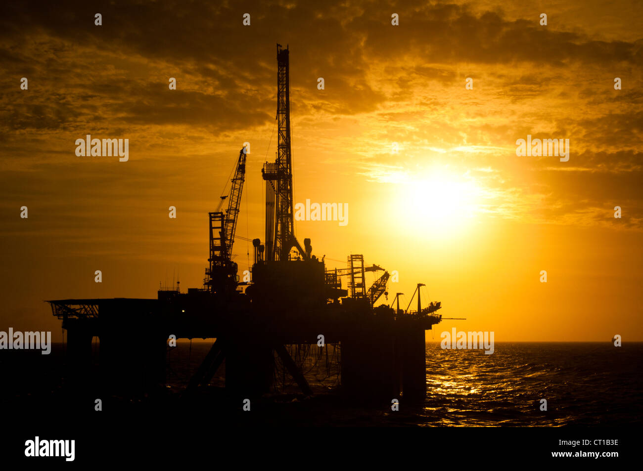 silhouette of offshore oil drilling rig in sunset/sunrise time. Coast ...