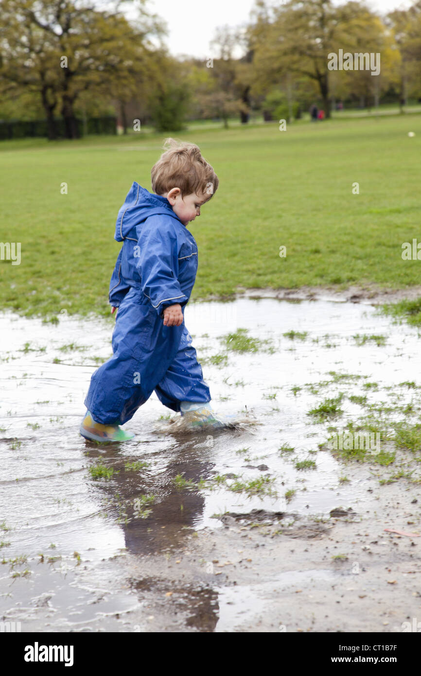 Toddler boy walking in puddle Stock Photo - Alamy