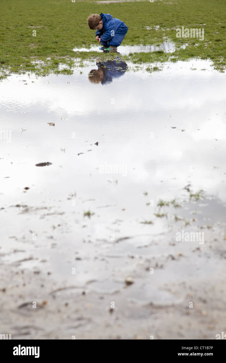 Toddler boy walking in puddle Stock Photo - Alamy
