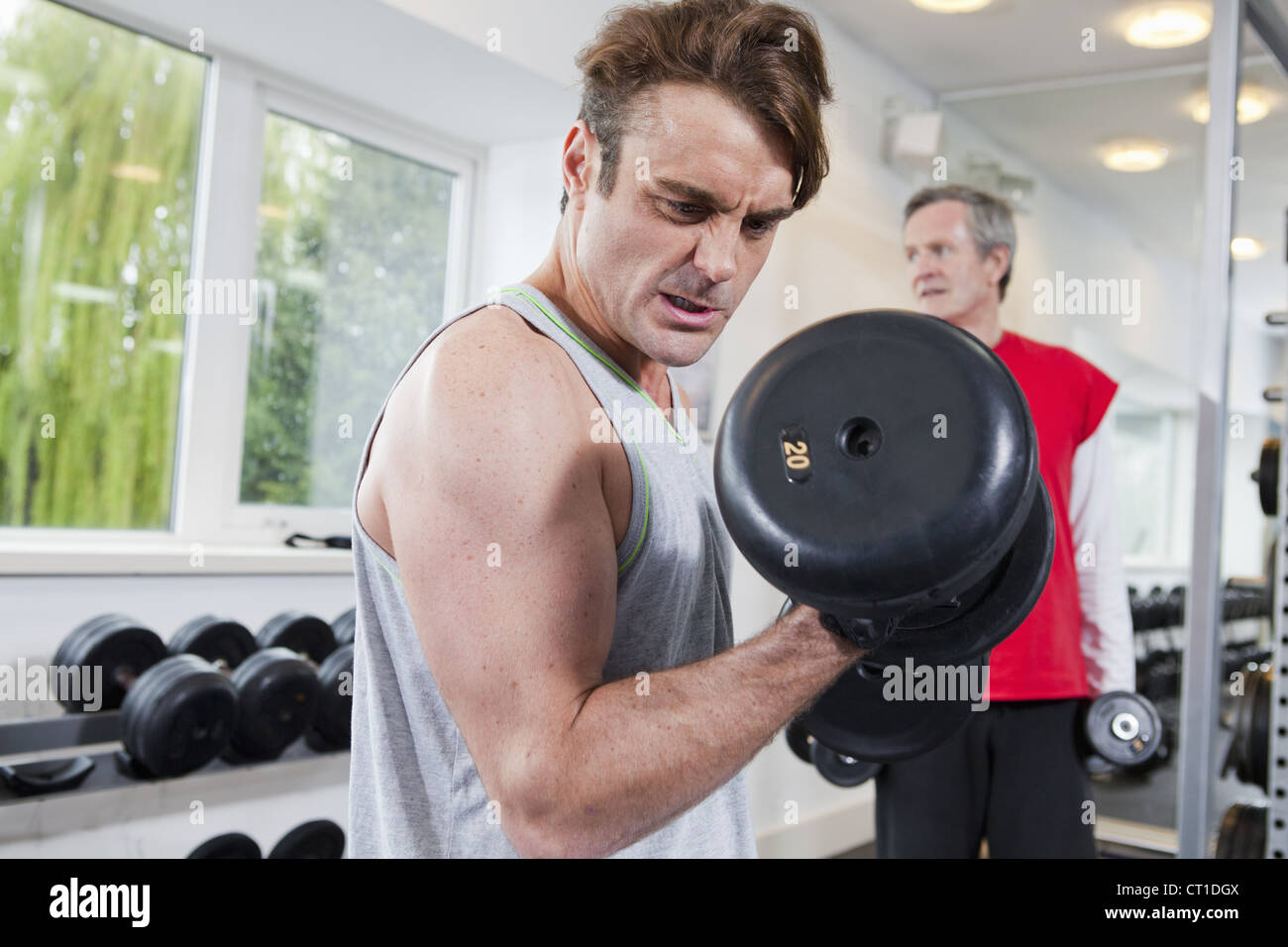 Man lifting weights in gym Stock Photo - Alamy