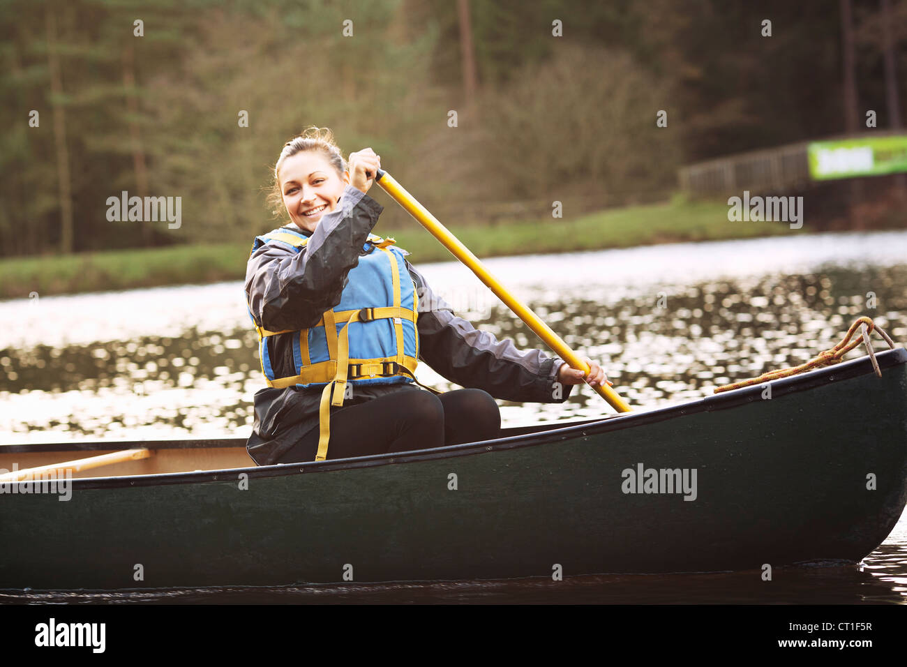 Woman rowing canoe on still lake Stock Photo - Alamy