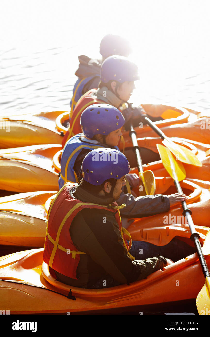 Kayakers rowing together on still lake Stock Photo - Alamy