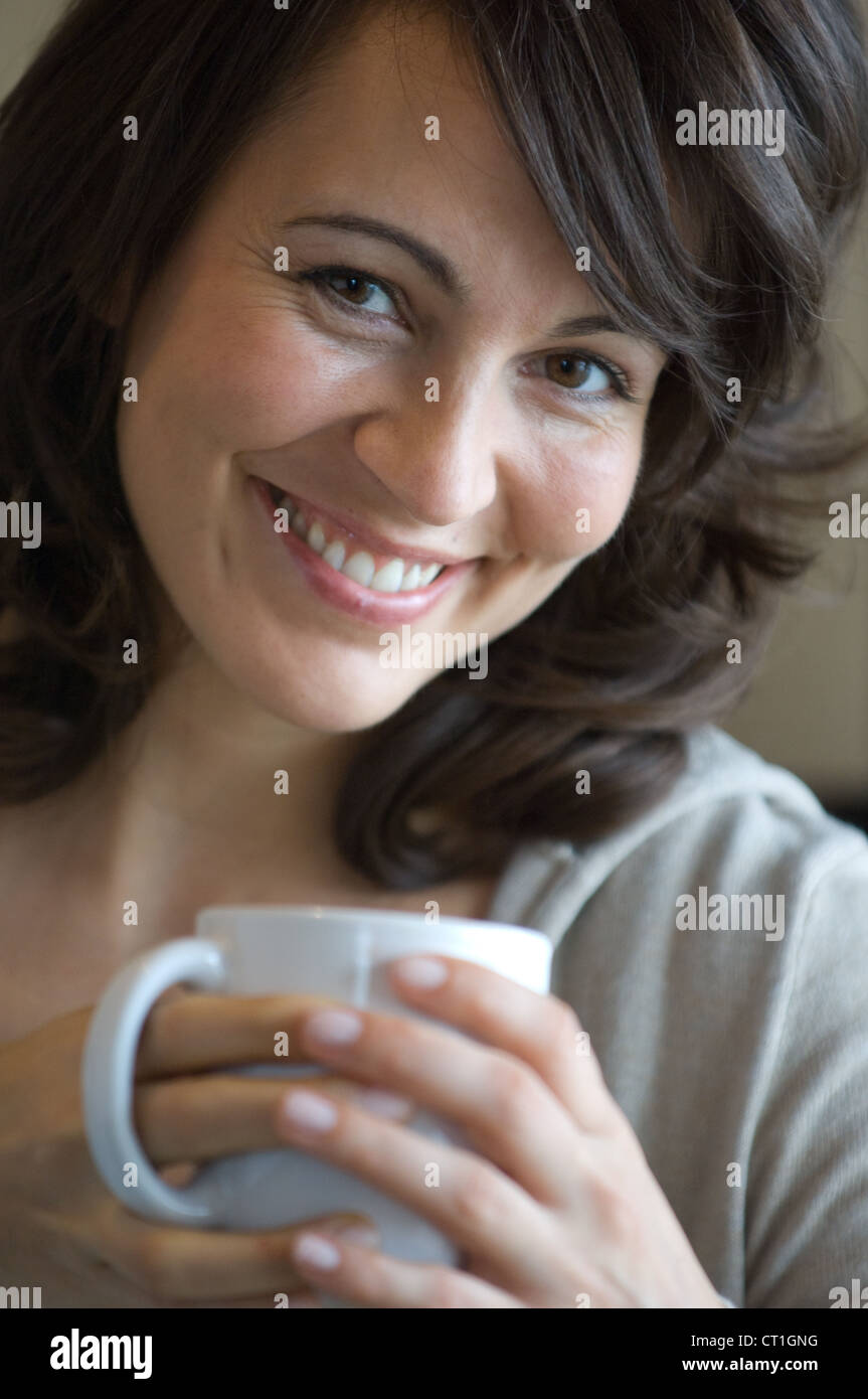 Smiling woman having cup of coffee Stock Photo - Alamy