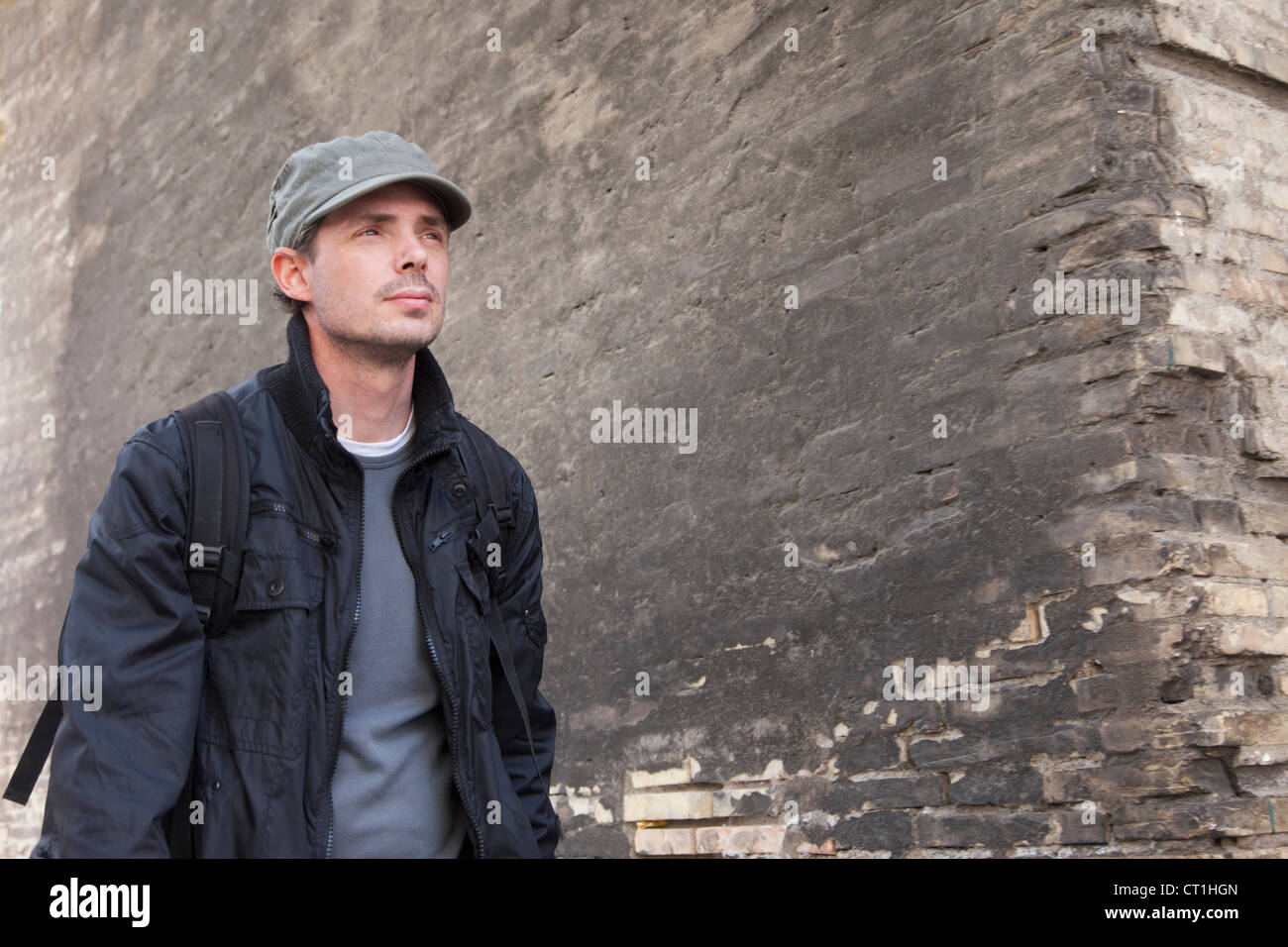 Man walking by concrete wall Stock Photo - Alamy