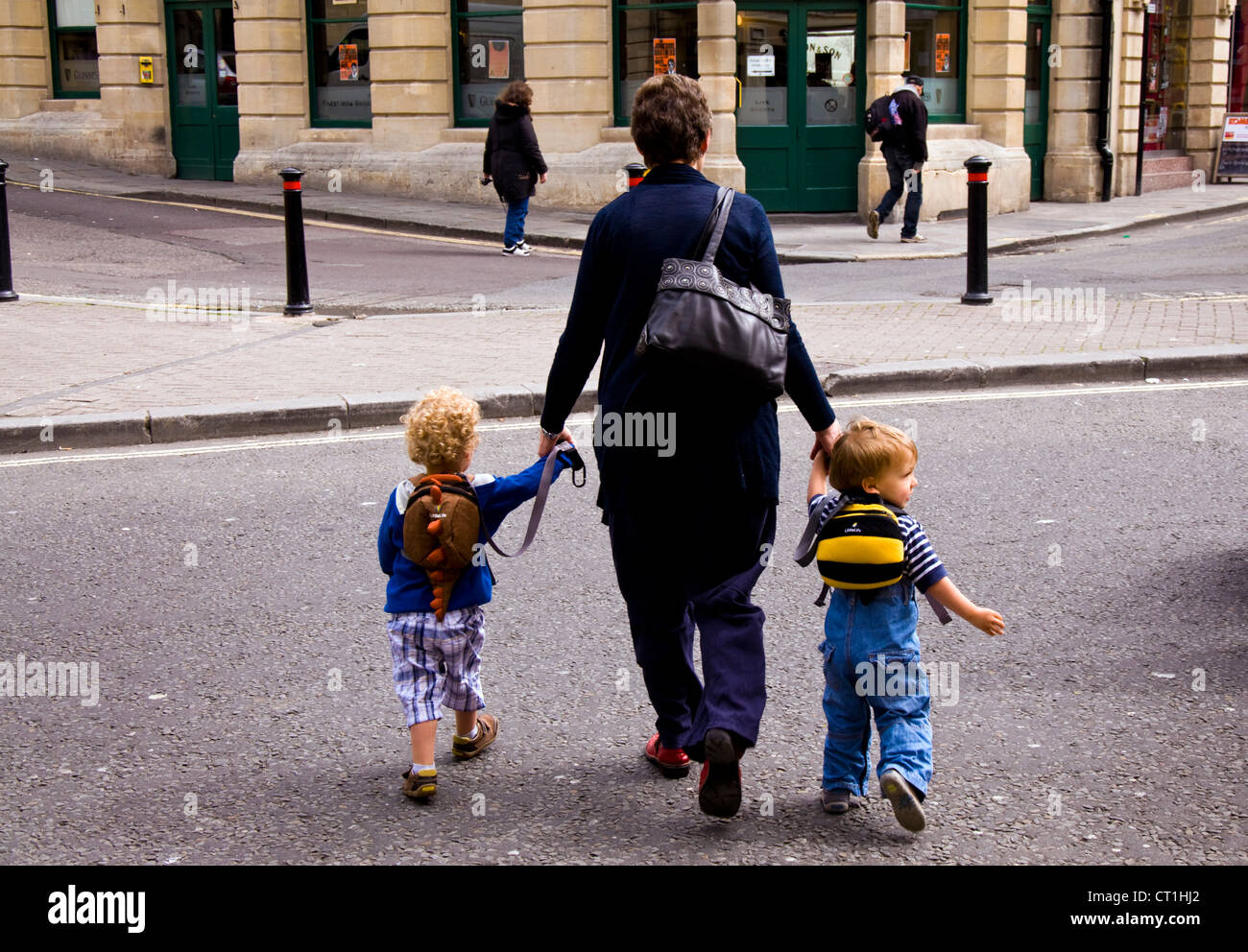 Mother with two young children crossing the road Stock Photo - Alamy