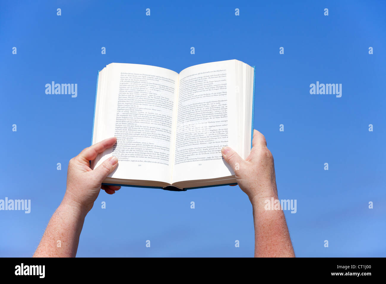 Woman's hands keep an open book in the blue sky Stock Photo - Alamy