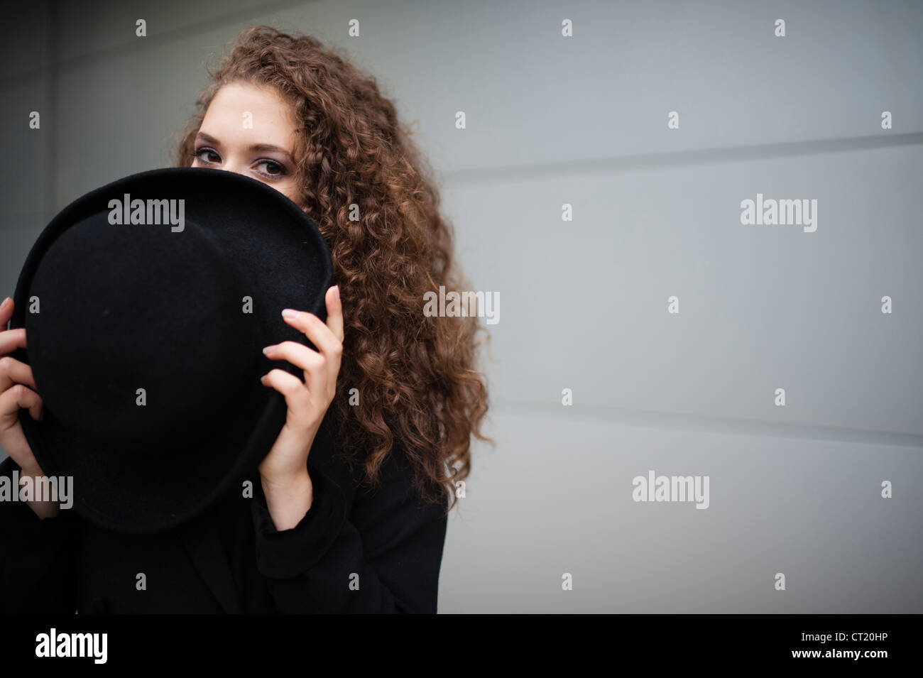 A Young 20 Year Old Slim Attractive Woman Girl Hiding Her Face Behind A Big Black Hat Uk Stock