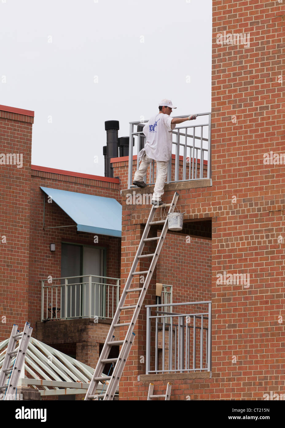 A man working atop a ladder Stock Photo - Alamy