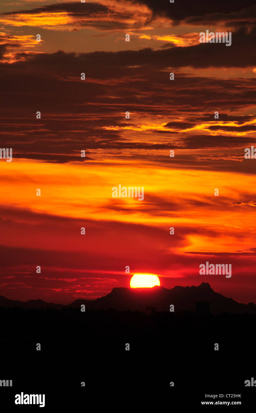 A sunset colors the sky during monsoon season in the Sonoran Desert ...