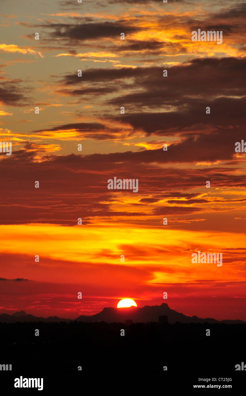 A sunset colors the sky during monsoon season in the Sonoran Desert ...