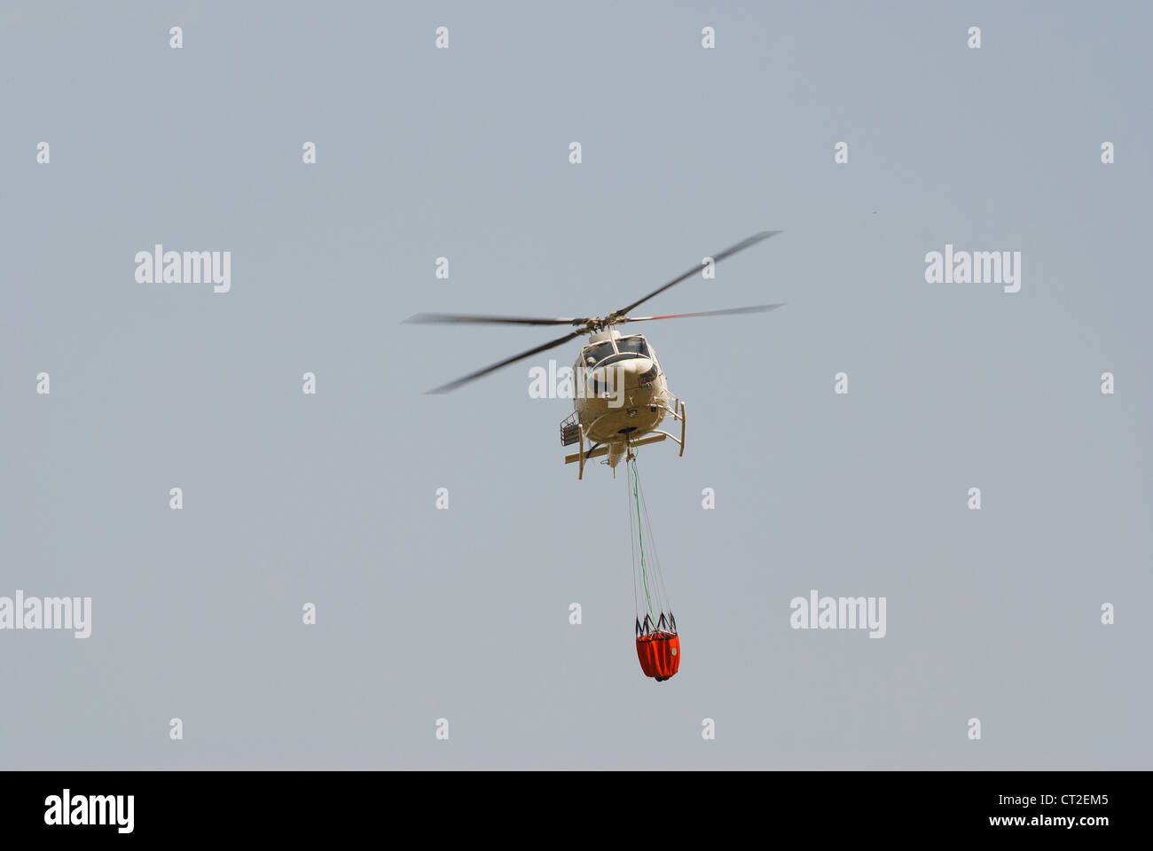 Firefighter helicopter in flight while on a fire extinguishing mission ...