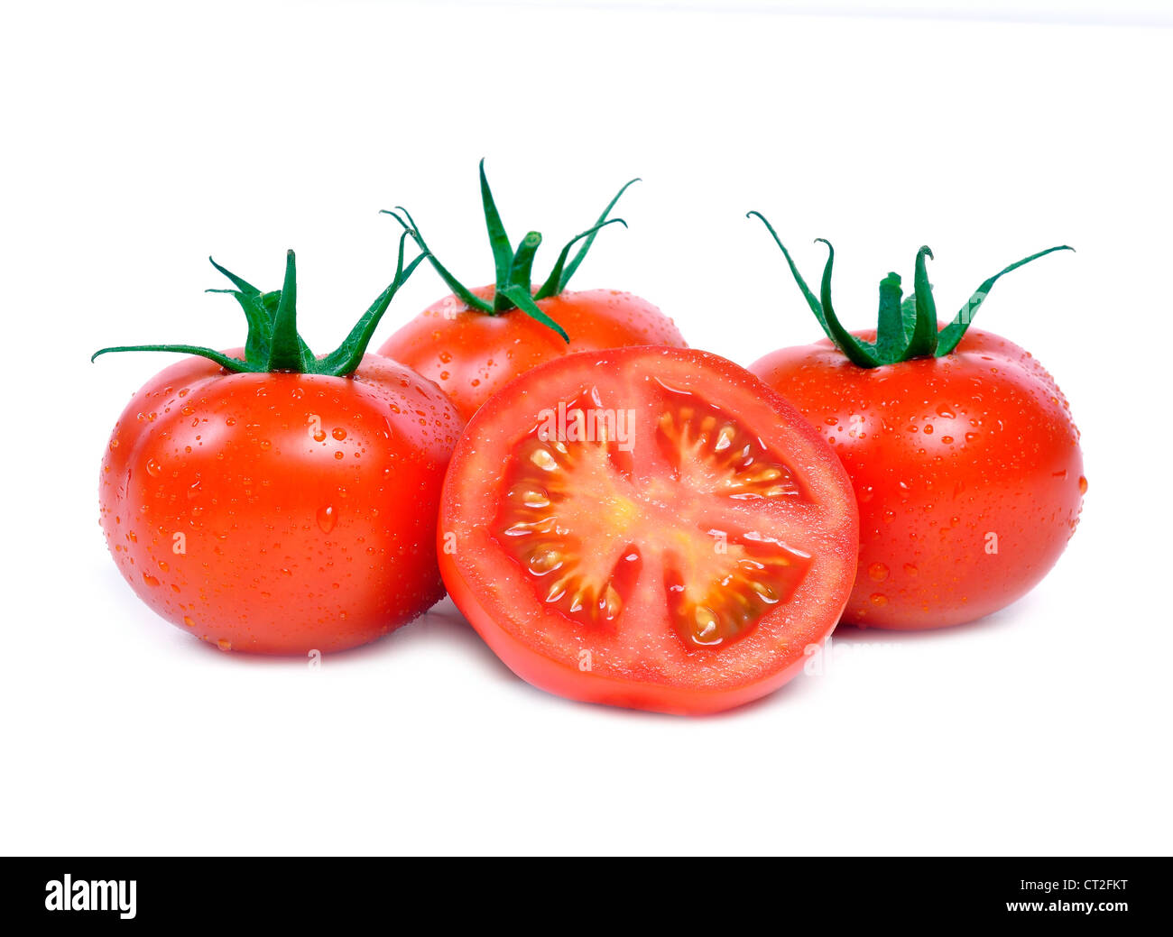 Three tomatoes and one half on white background Stock Photo - Alamy